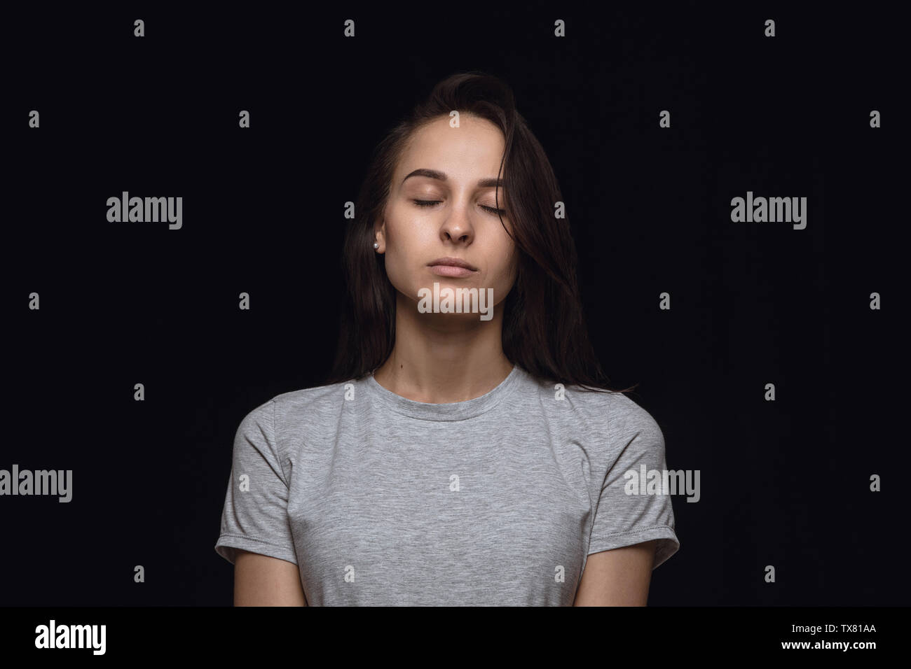 Close up portrait of young woman isolated on black studio background ...