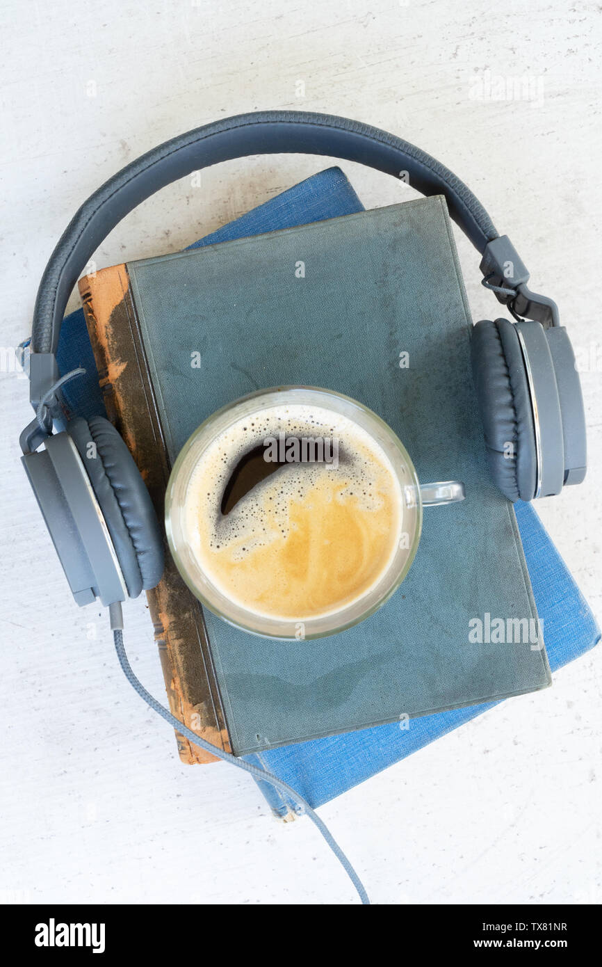 Audio book concept. Headphones with books and cup of fresh coffee on ...
