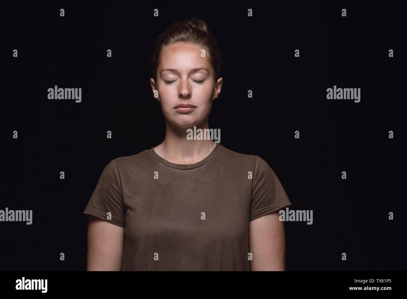 Close up portrait of young woman isolated on black studio background ...
