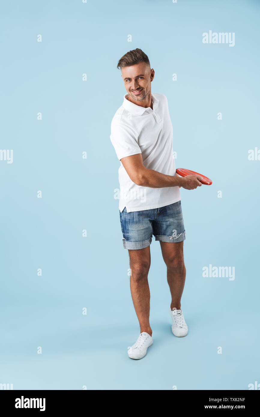 Photo of a handsome adult man posing isolated over blue wall background ...