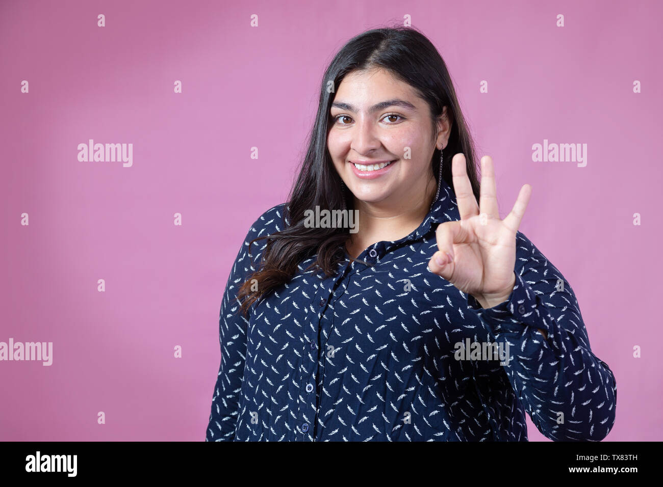 Beautiful smiling woman showing number 3 with fingers or ok symbol in ...