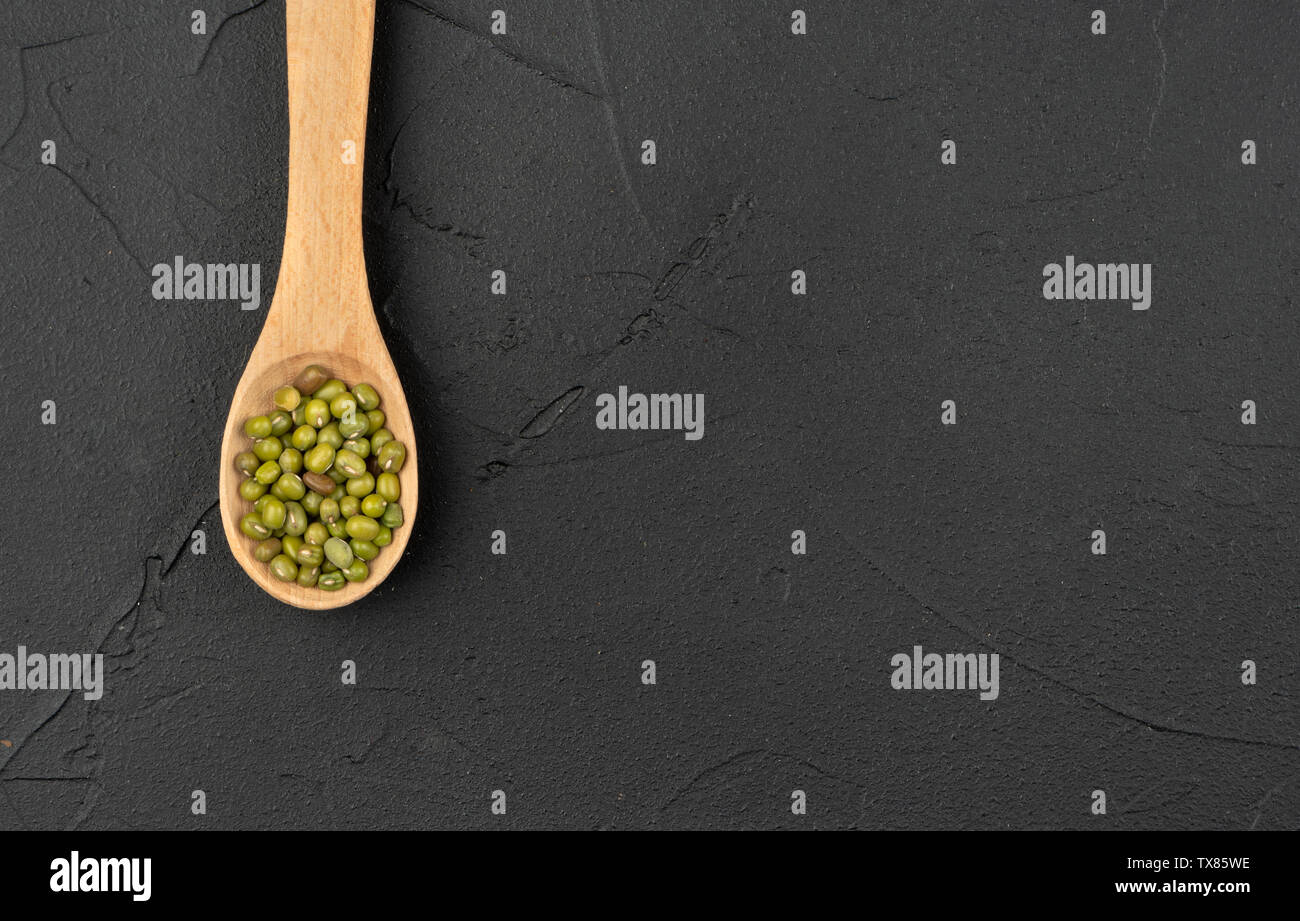 Small spoon with green mung beans on a dark background, top view Stock ...