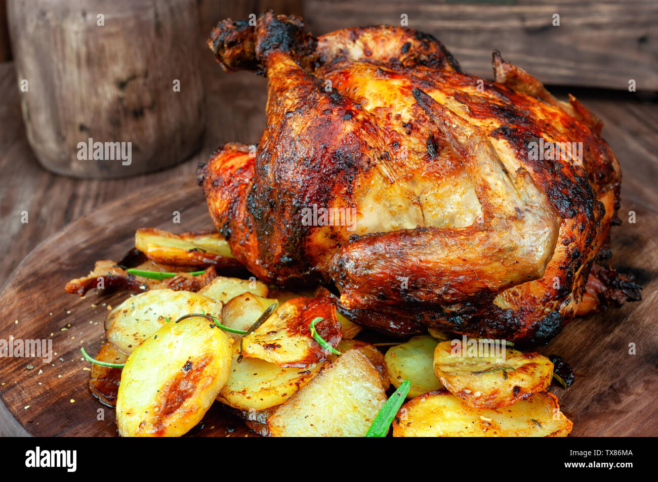 Roasted chicken with potato on wooden table Stock Photo - Alamy