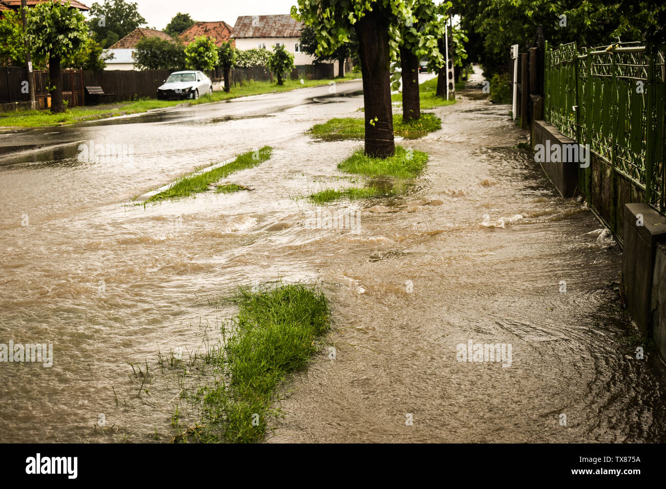 Flooded city street after thunderstorm. The road and the sidewalk are ...