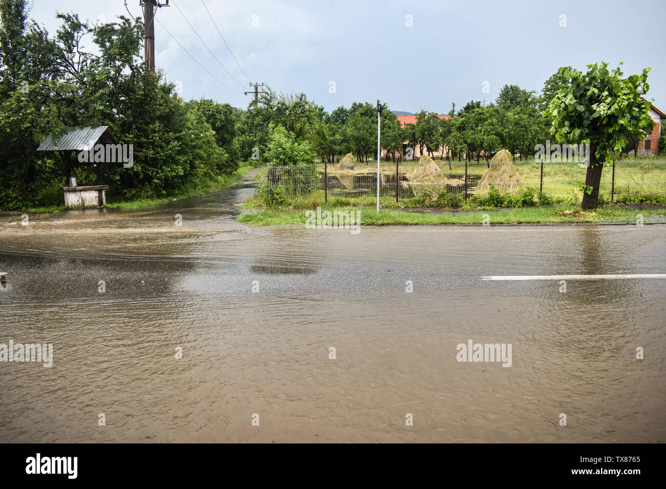 Flooded city street after thunderstorm. The road and the sidewalk are ...