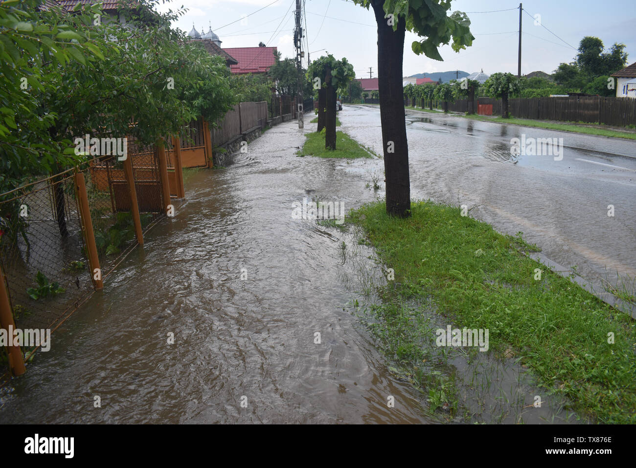 Flooded city street after thunderstorm. The road and the sidewalk are ...