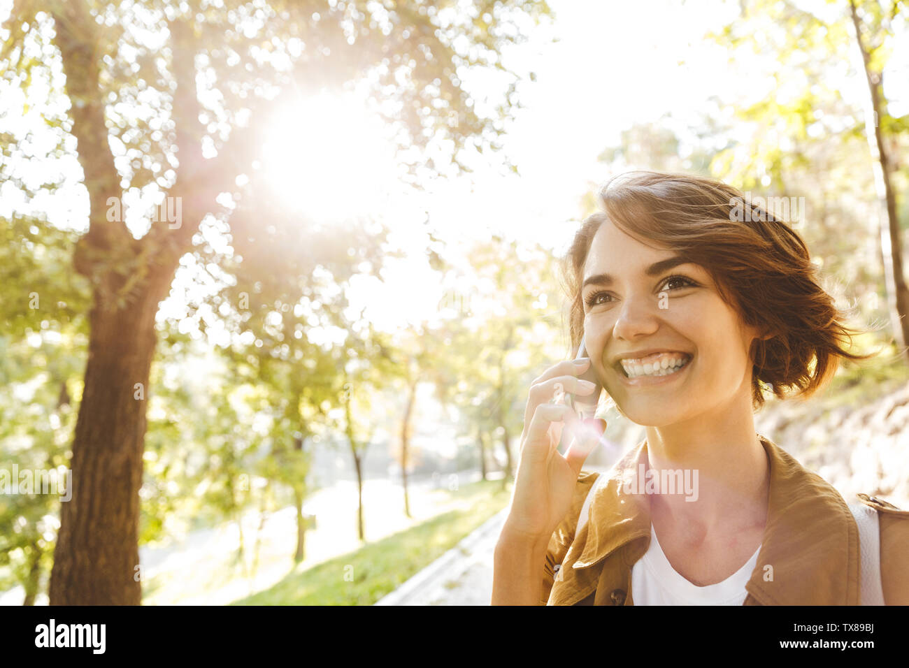 Image of a cute young amazing woman walking outdoors in park in ...