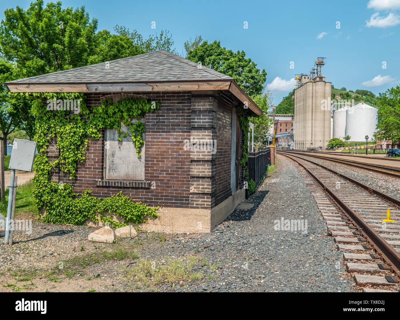 Small railroad building boarded up alongside the train tracks that flow ...
