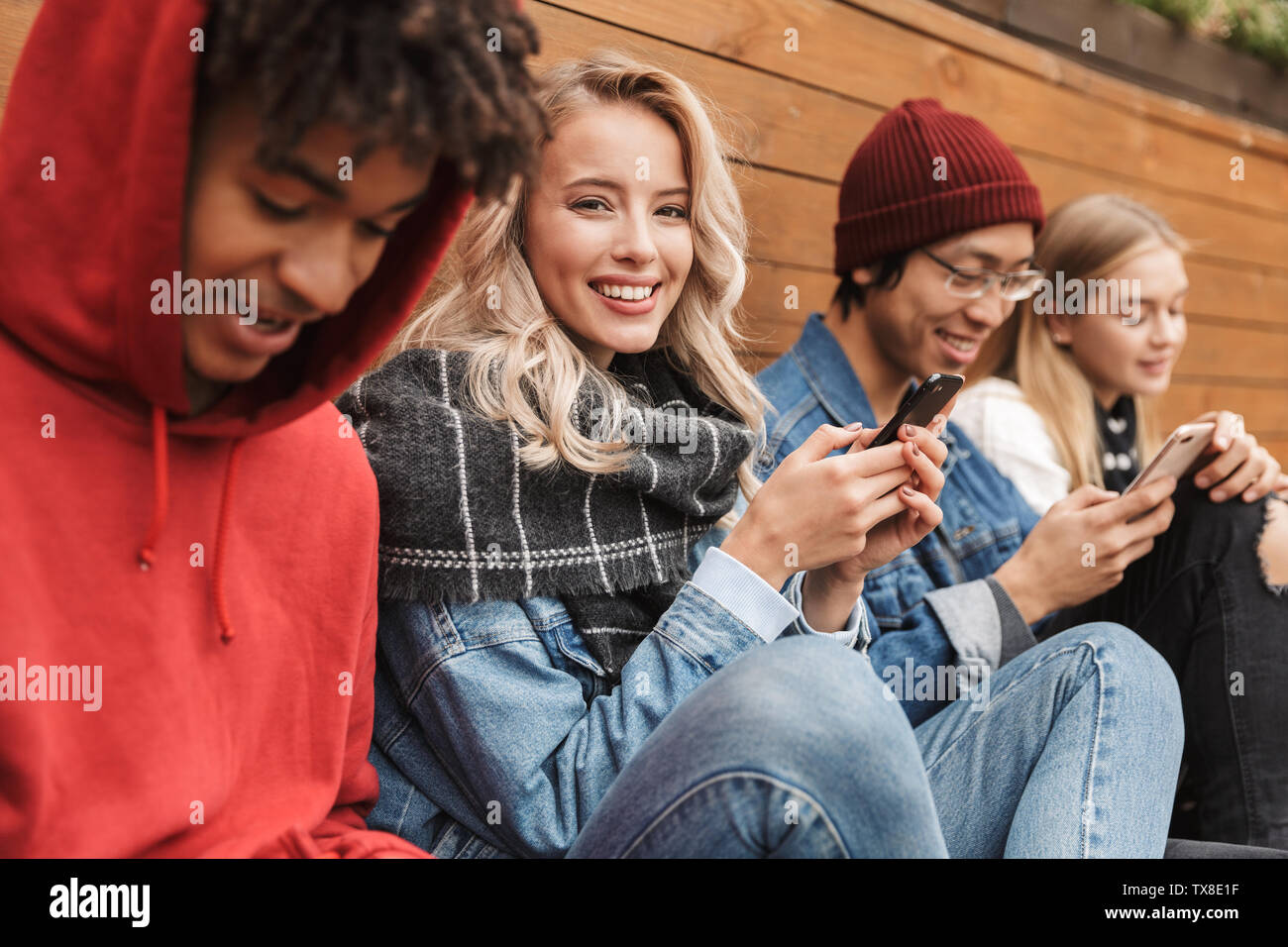 Happy multhietnic friends students hanging out together outdoors, using ...