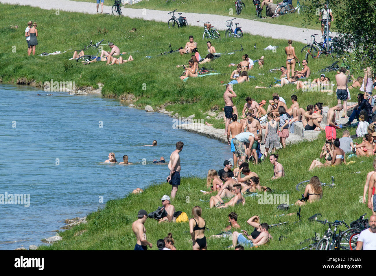 Munich, Germany. 24th June, 2019. Numerous people sunbathe on the Isar ...