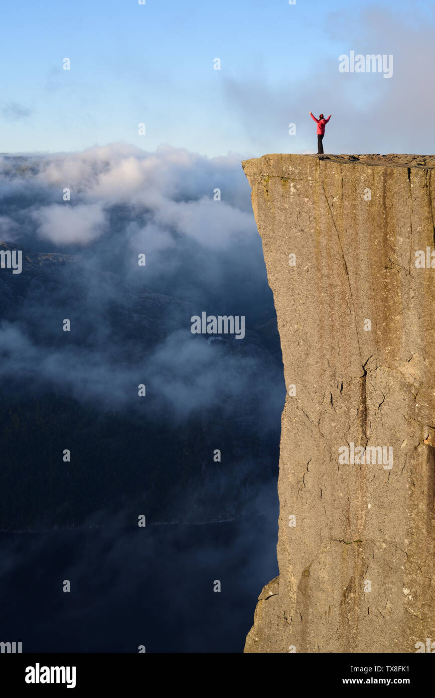 Preikestolen - amazing rock in Norway. Girl standing on a cliff above ...