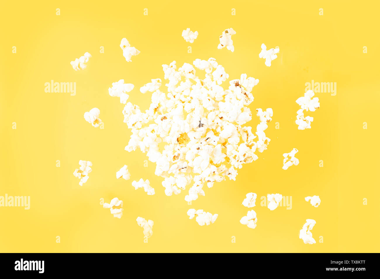 Scattered popcorn over yellow background, top view Stock Photo - Alamy
