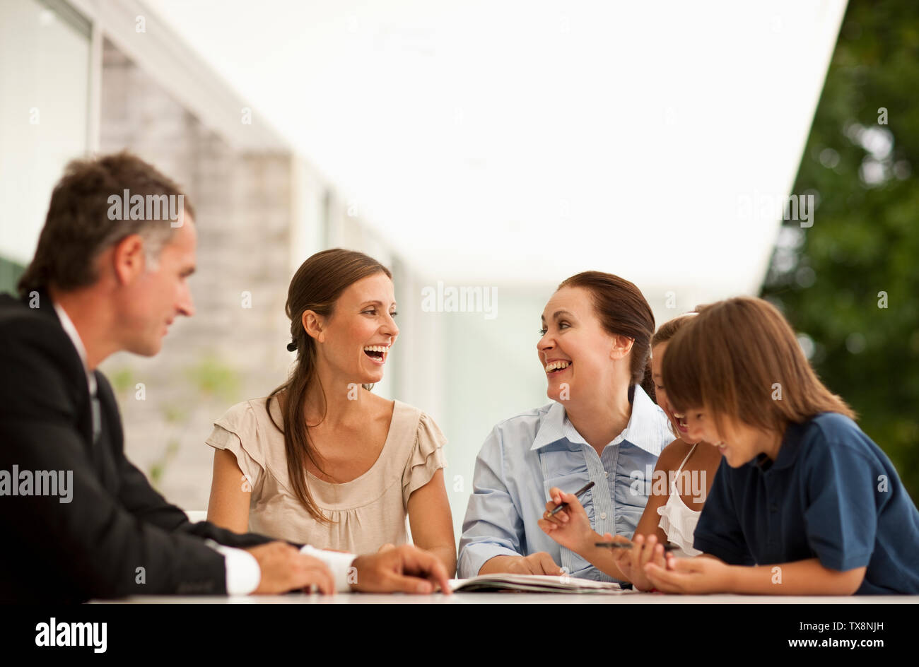 Family having a meeting on their patio with a businessman Stock Photo ...