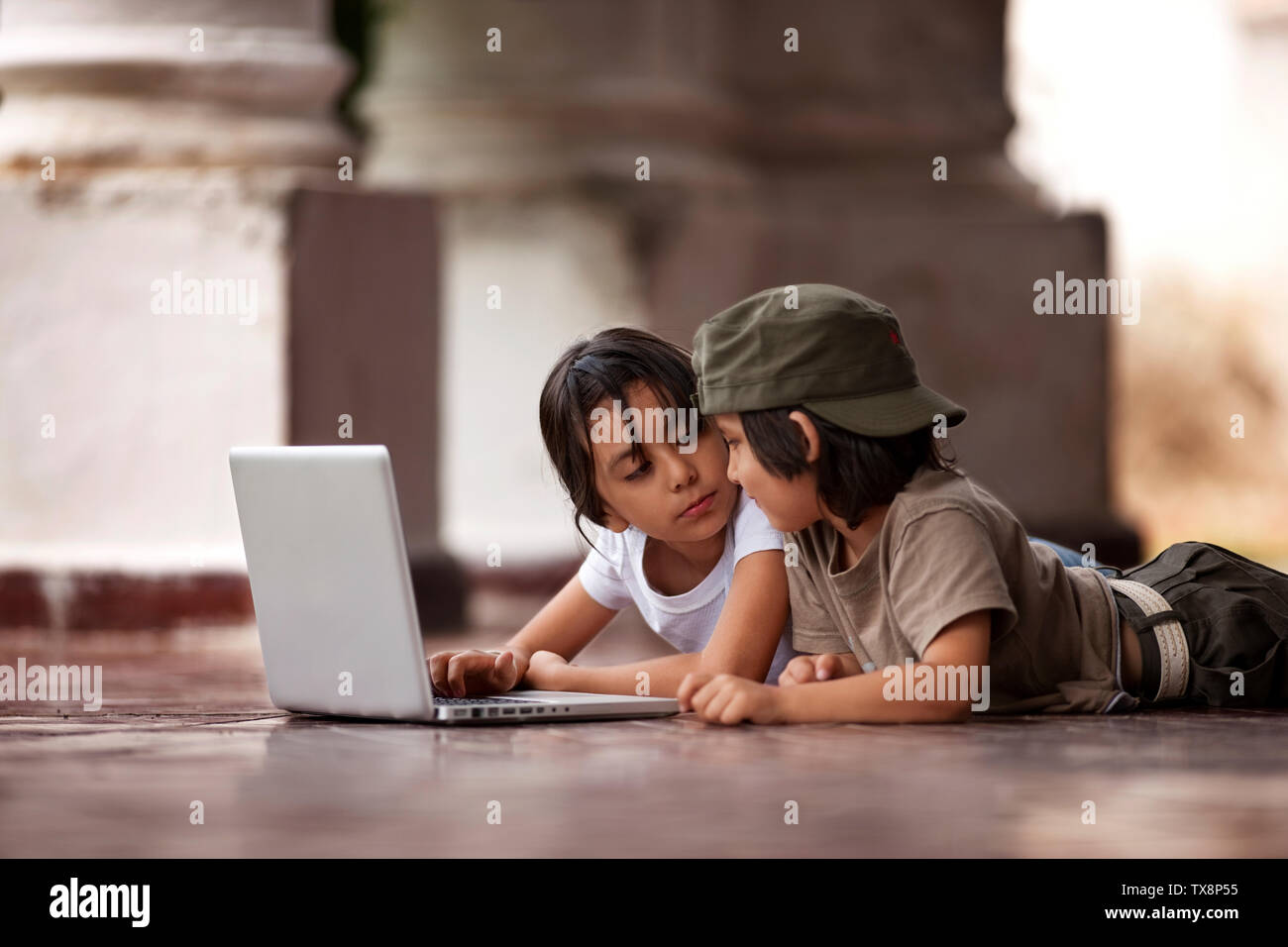 Little brother and sister using a laptop together Stock Photo - Alamy