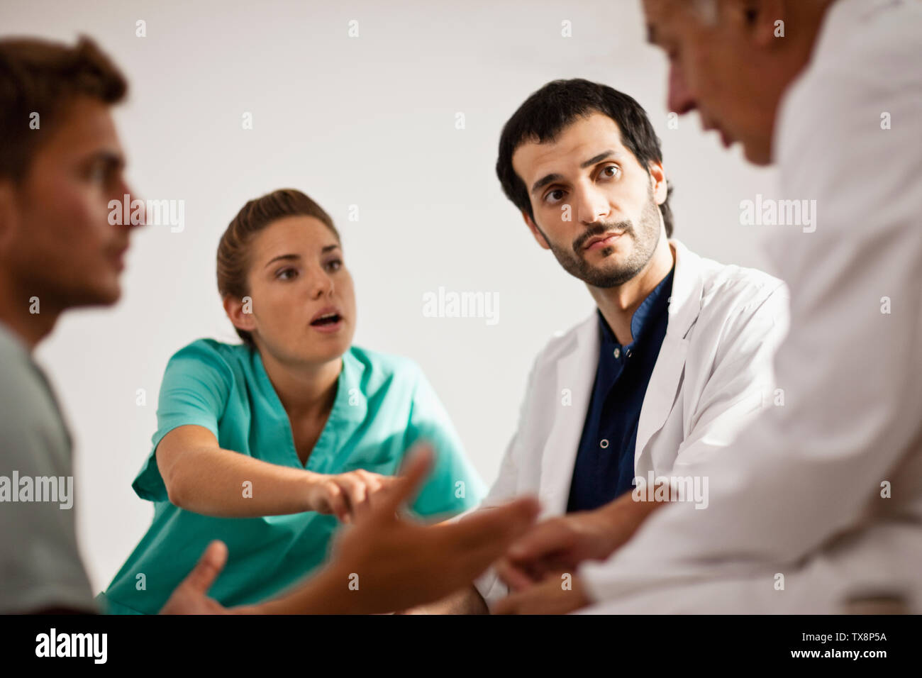 Small group of doctors and nurses talking and brainstorming together ...