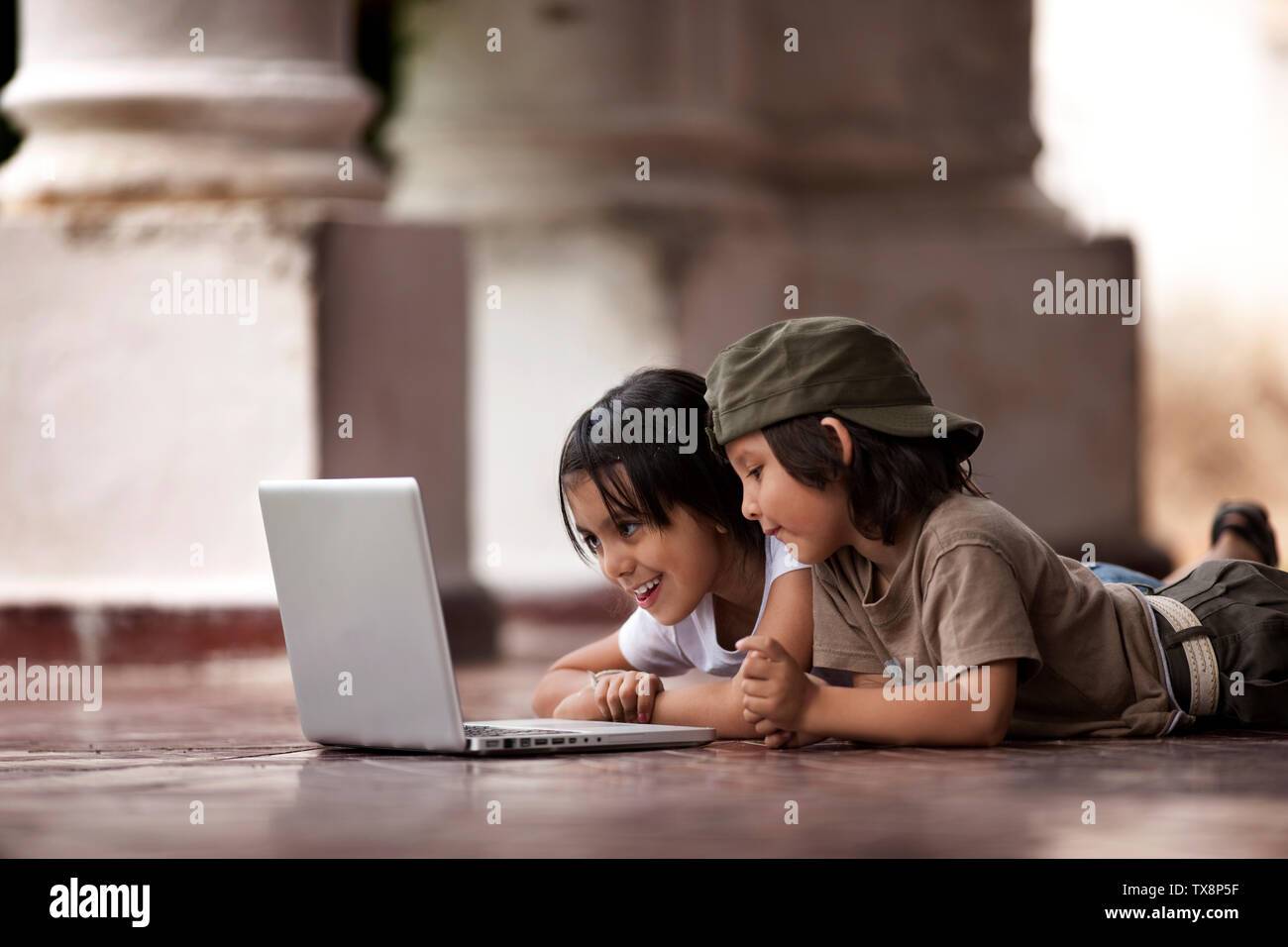 Little brother and sister using a laptop together Stock Photo - Alamy
