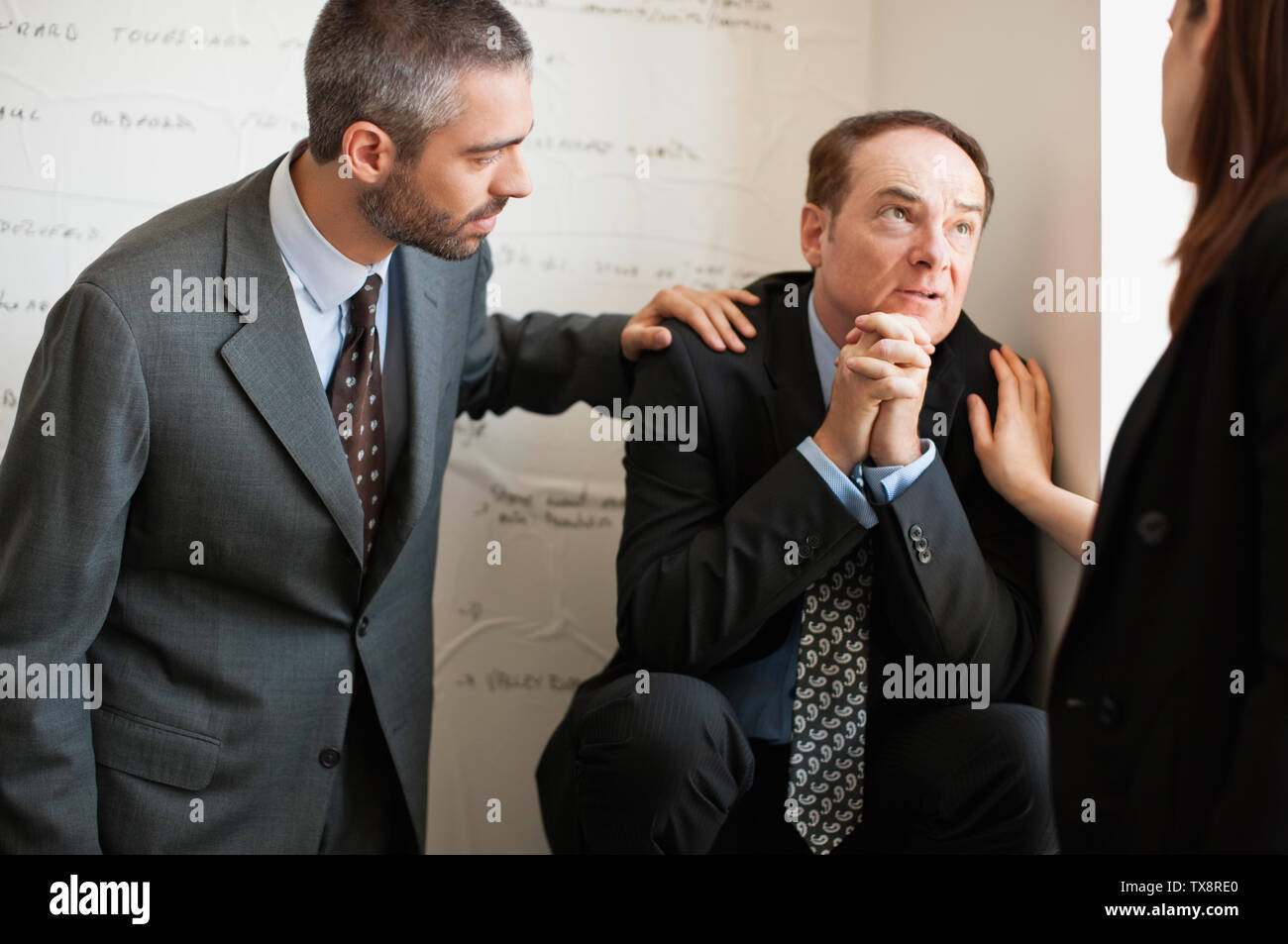 Two business people comfort another Stock Photo - Alamy