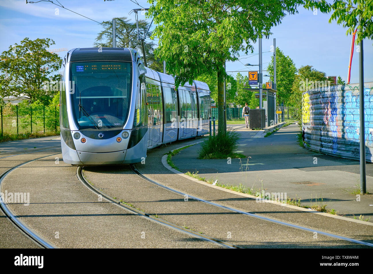 City tram, with city branding, advancing on tracks before reaching ...