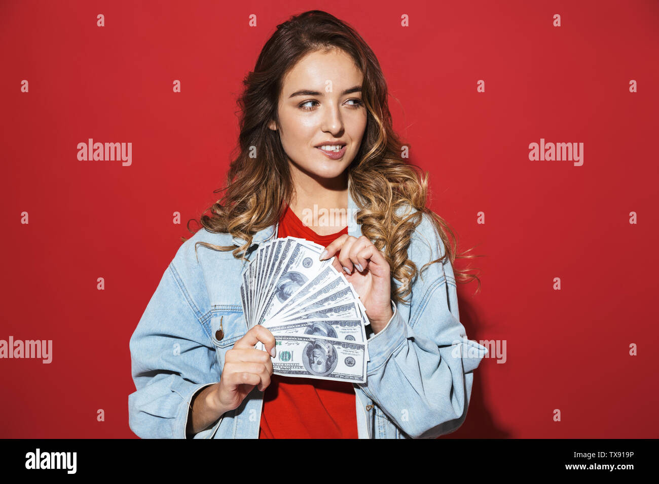Portrait of a cheerful stylish young woman wearing denim jacket ...