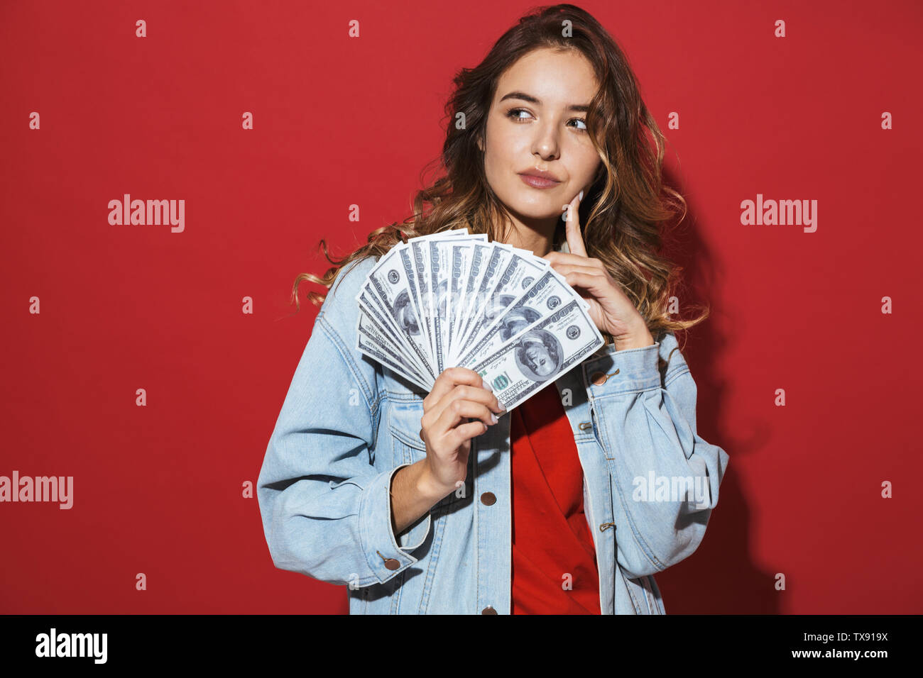 Portrait of a cheerful stylish young woman wearing denim jacket ...