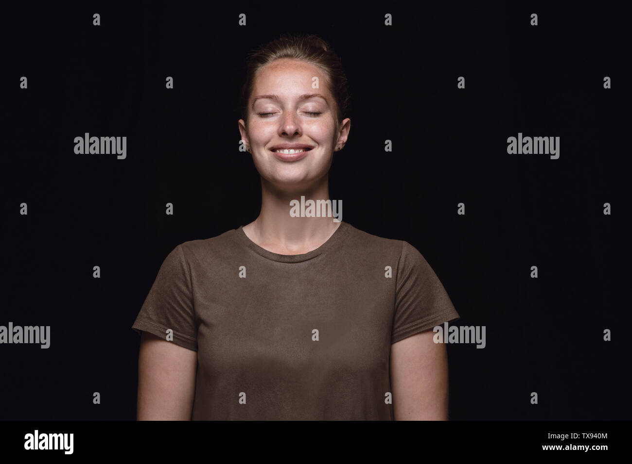 Close up portrait of young woman isolated on black studio background ...