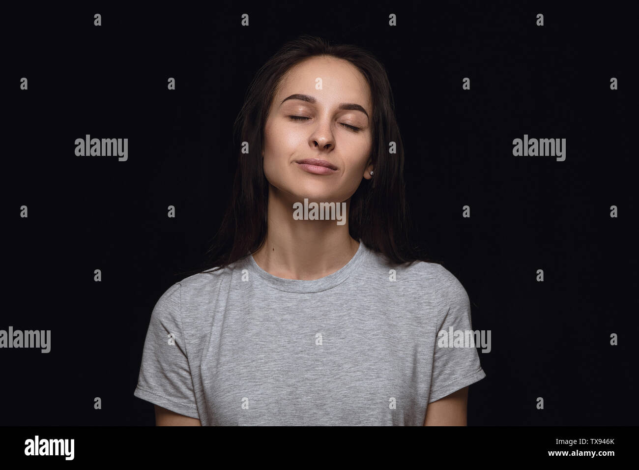 Close up portrait of young woman isolated on black studio background ...