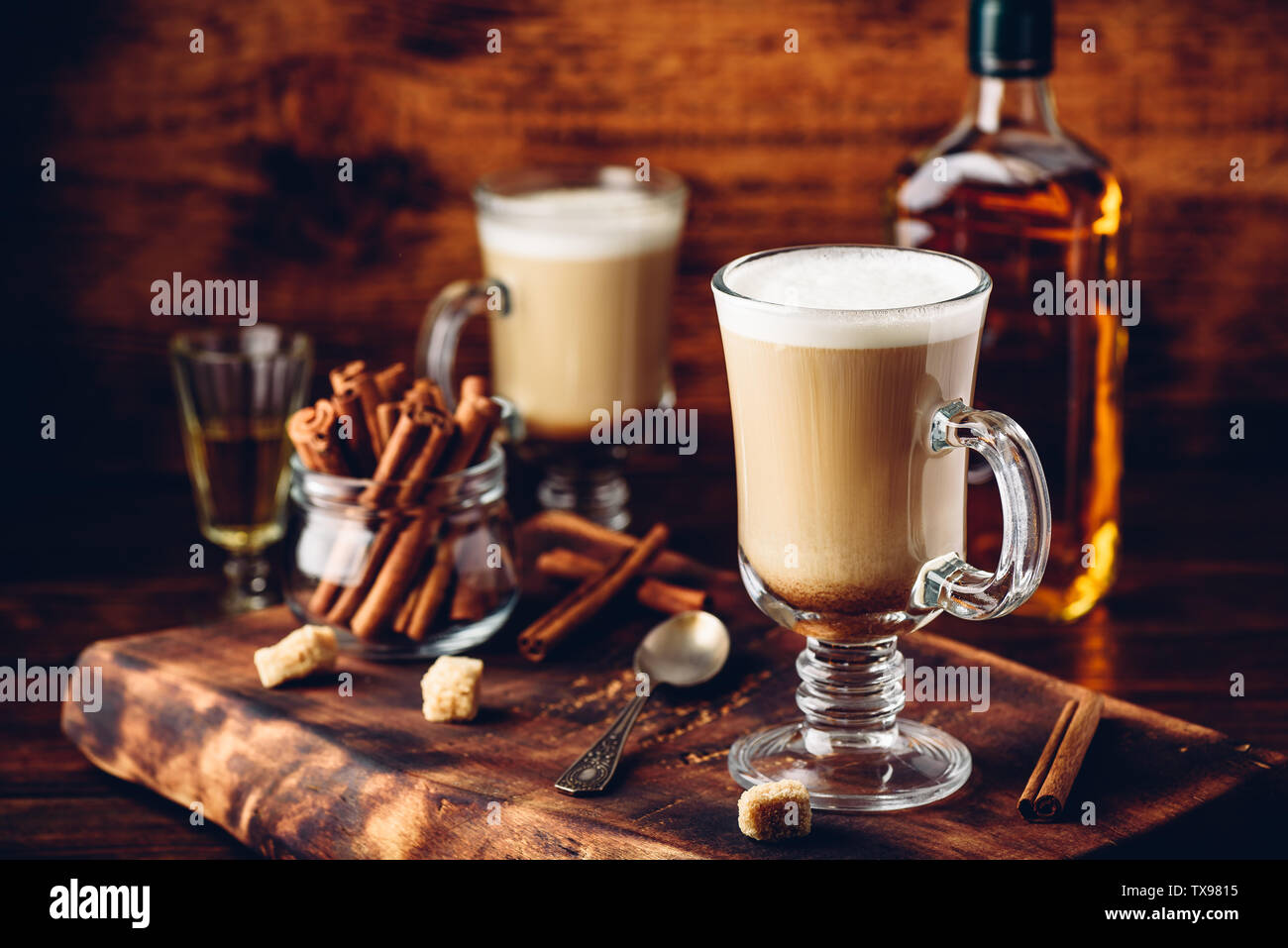 Coffee with Irish whiskey and whipped cream in glass on rustic wooden ...