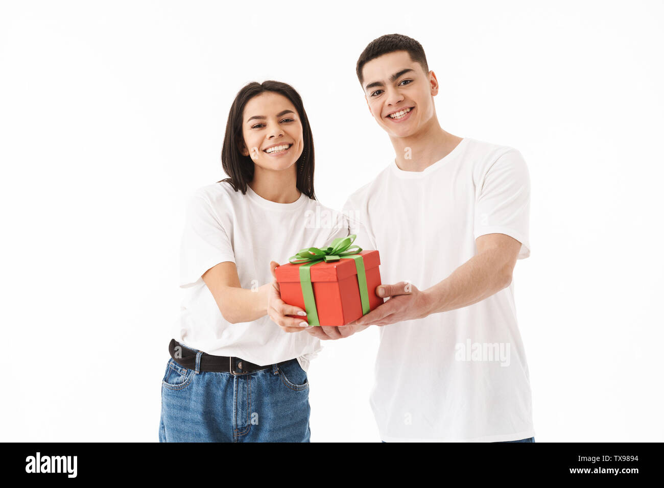 Attractive young couple standing isolated over white background ...