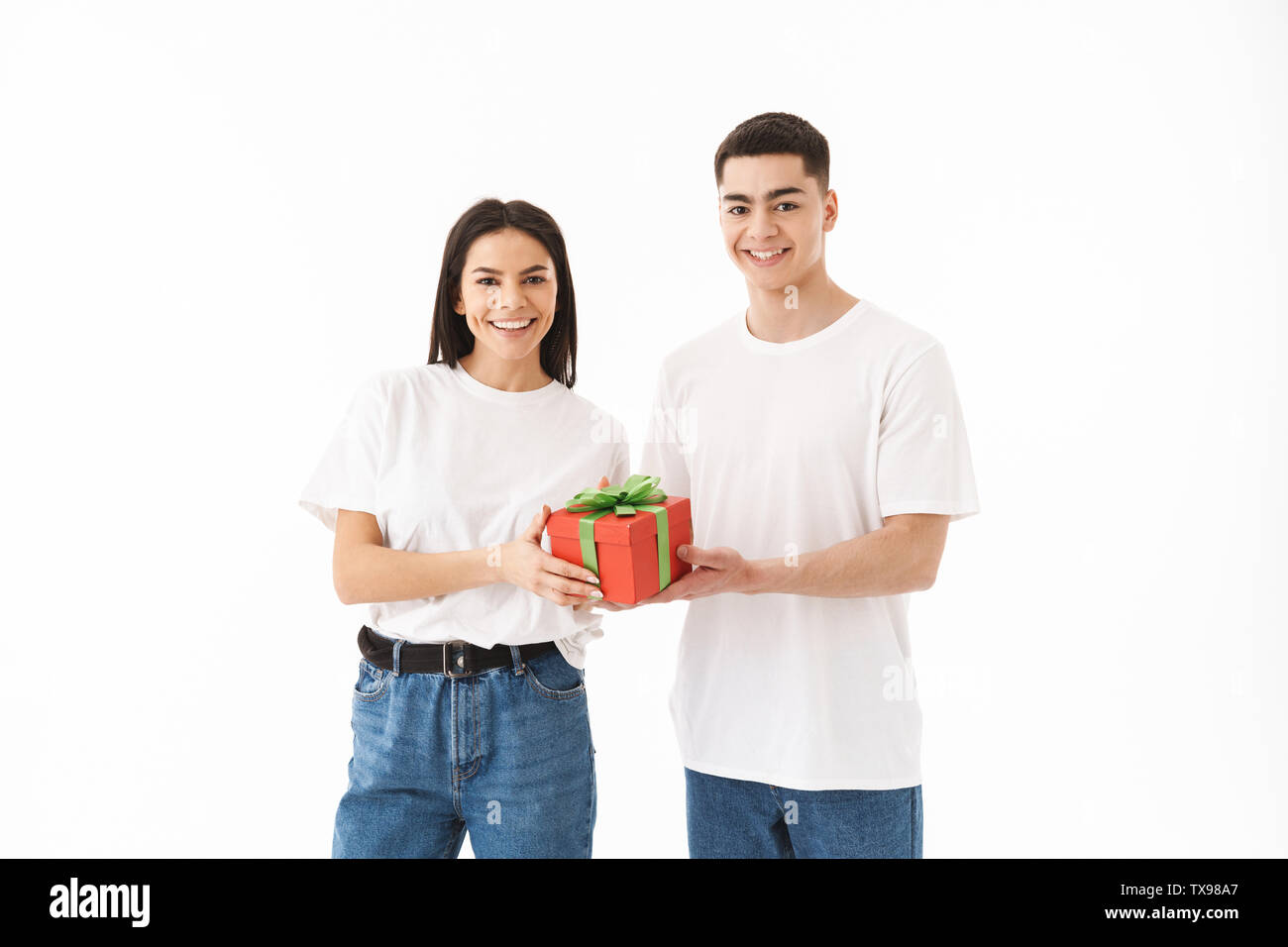 Attractive young couple standing isolated over white background ...