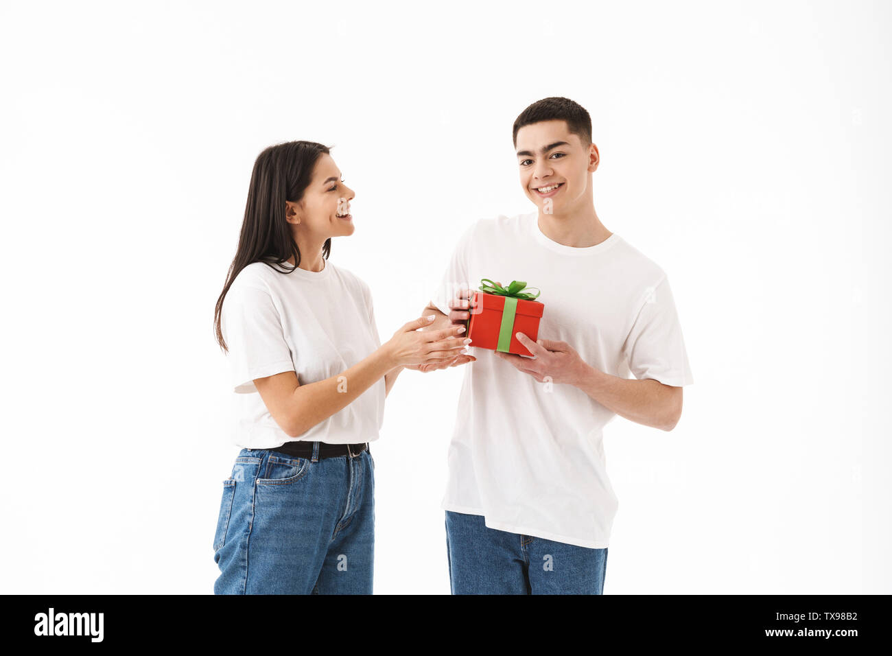 Attractive young couple standing isolated over white background ...