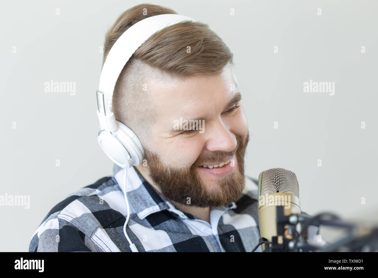Radio and DJ concept - Man with microphone and big headphone is smiling ...