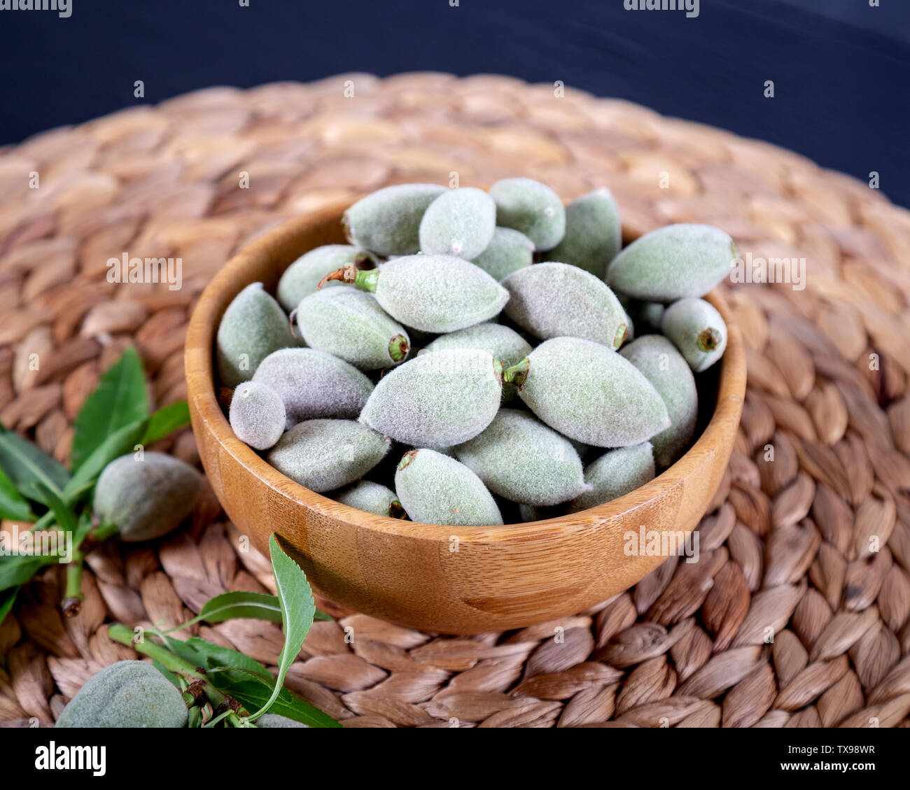 Fresh green almonds in a wooden bowl on white background Stock Photo ...