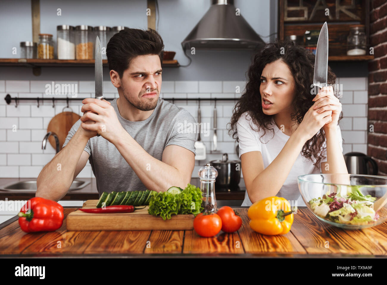 Picture of amusing funny couple man and woman 30s cooking salat with ...