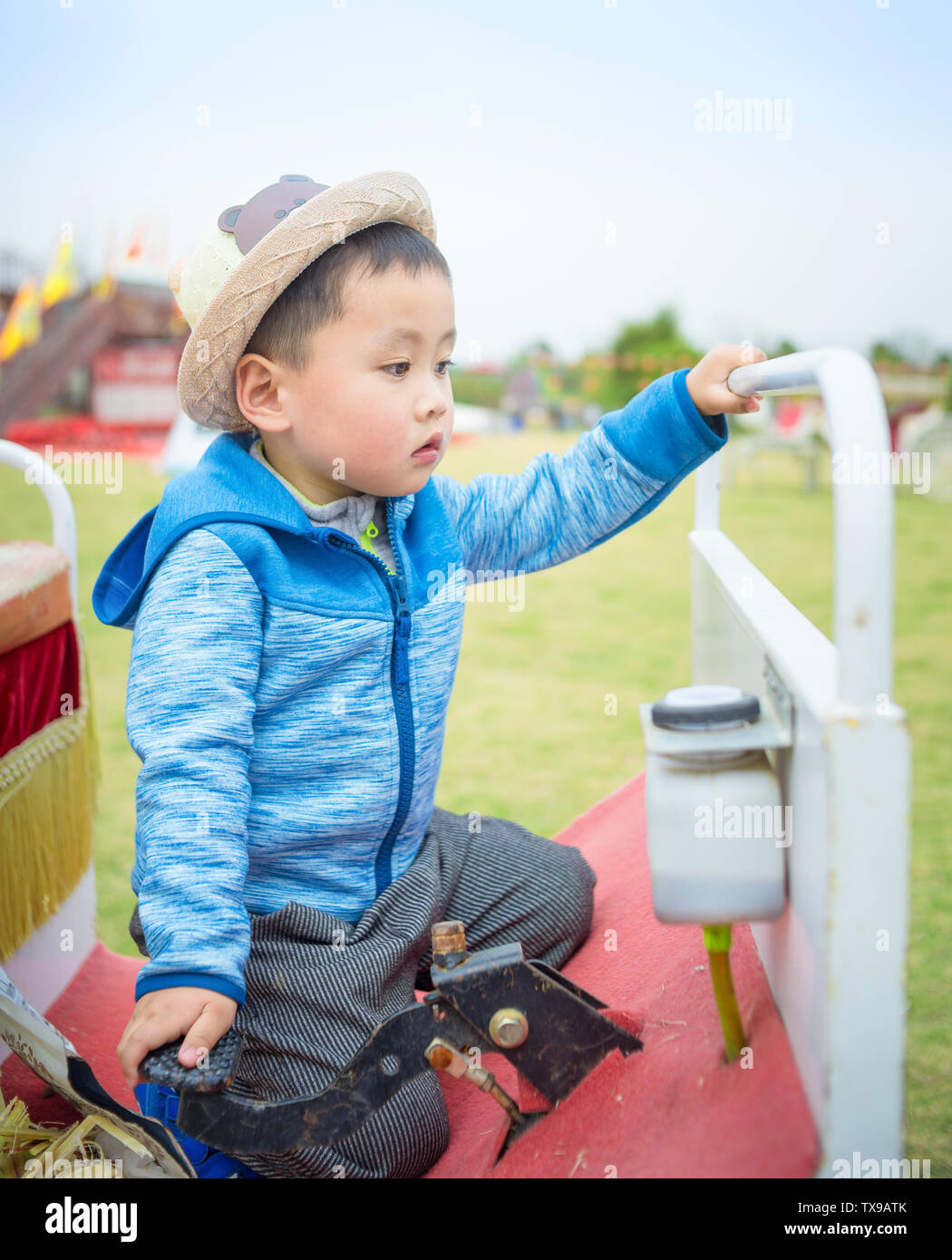 Photo of a 4-year-old boy playing in an amusement park full of green ...