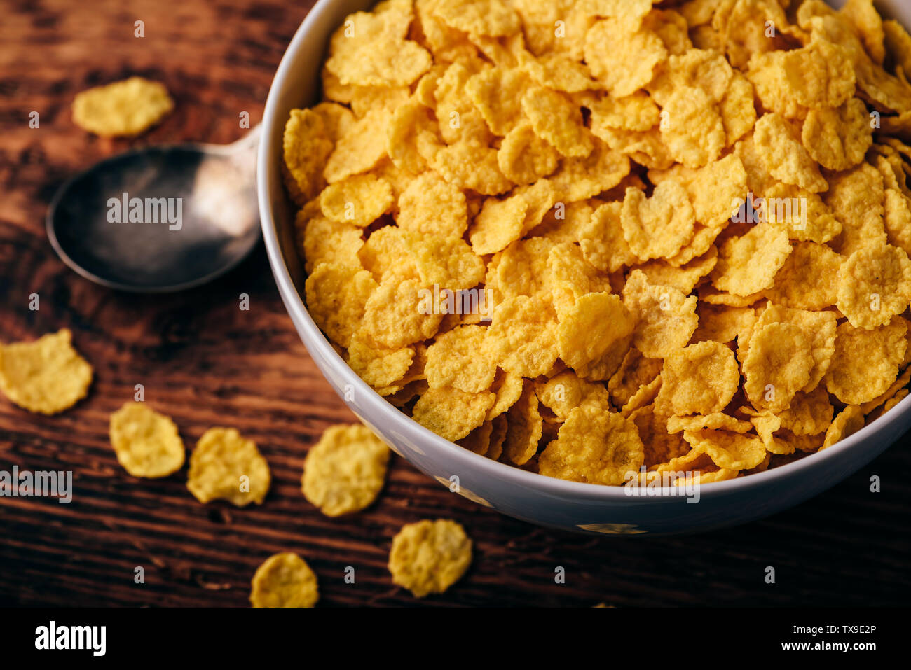 White bowl of corn flakes on a rustic wooden surface Stock Photo - Alamy