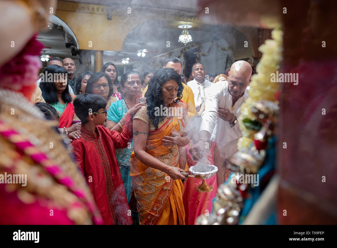 A beautiful Hindu women performs the ritual of aarti offering light ...