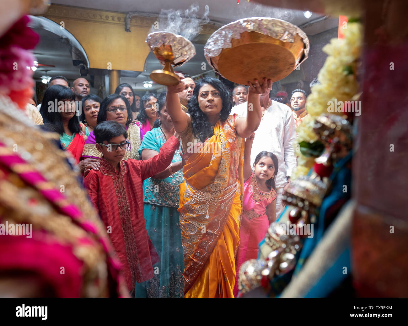 A beautiful Hindu women performs the ritual of aarti offering light ...