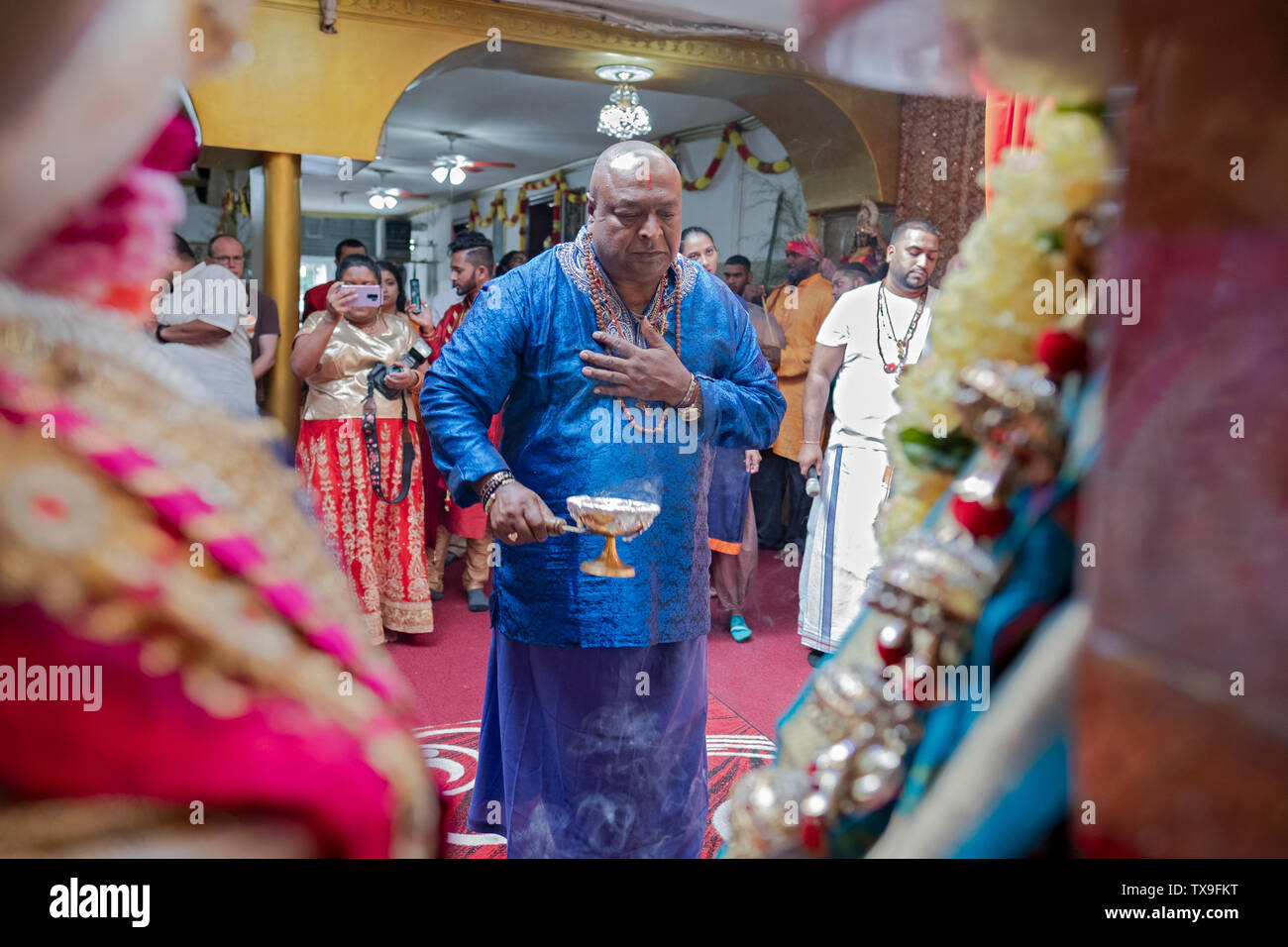 A Hindu man performs the ritual of aarti offering light & flames to the ...