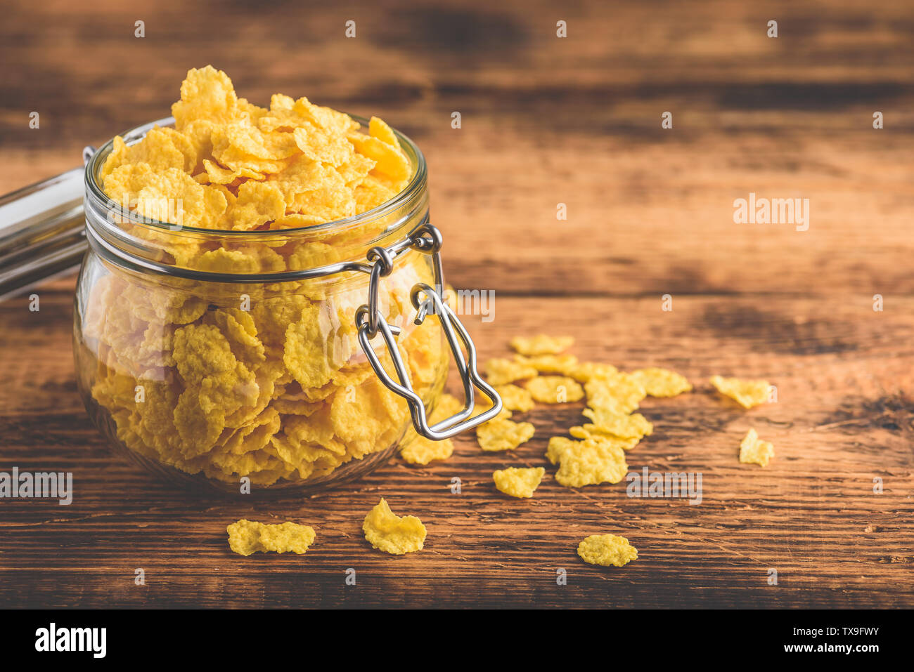 Corn flakes in a glass jar on wooden surface Stock Photo - Alamy