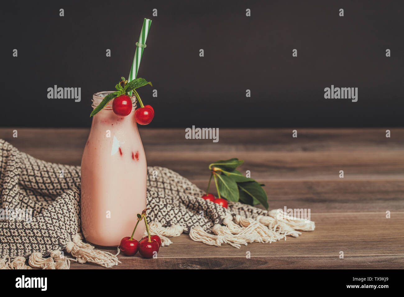 Cherry smoothie or milkshake in jar with fresh cherries on rustic ...