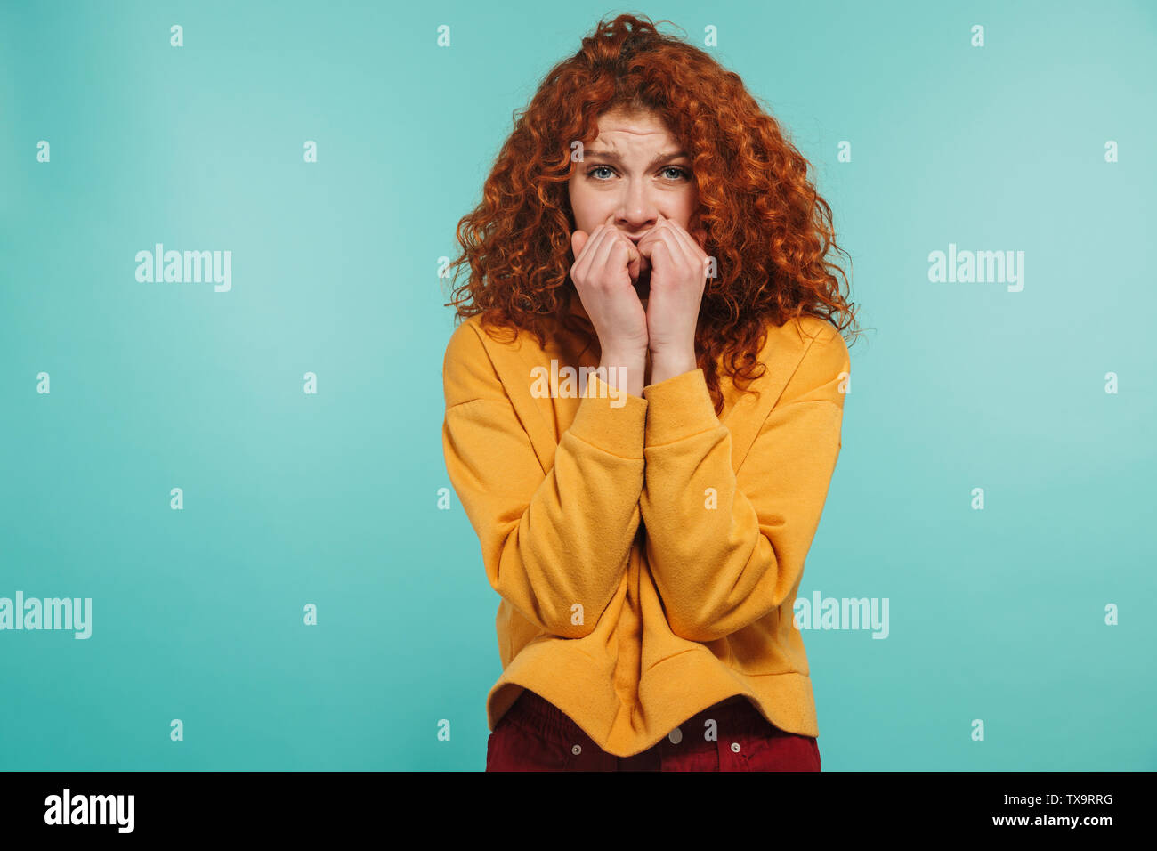 Photo of scared girl 20s with curly ginger hair looking at camera and ...