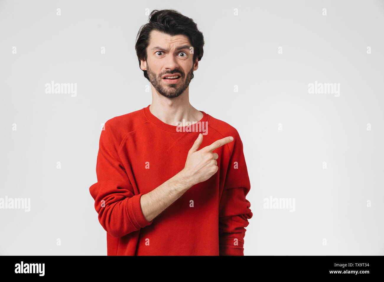Picture of a handsome young confused man posing isolated over white ...