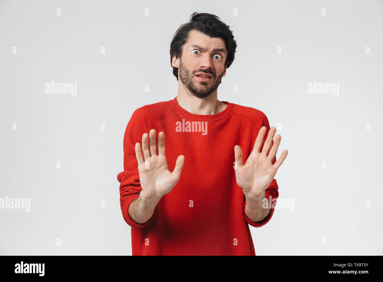 Picture of a handsome young scared man posing isolated over white wall ...