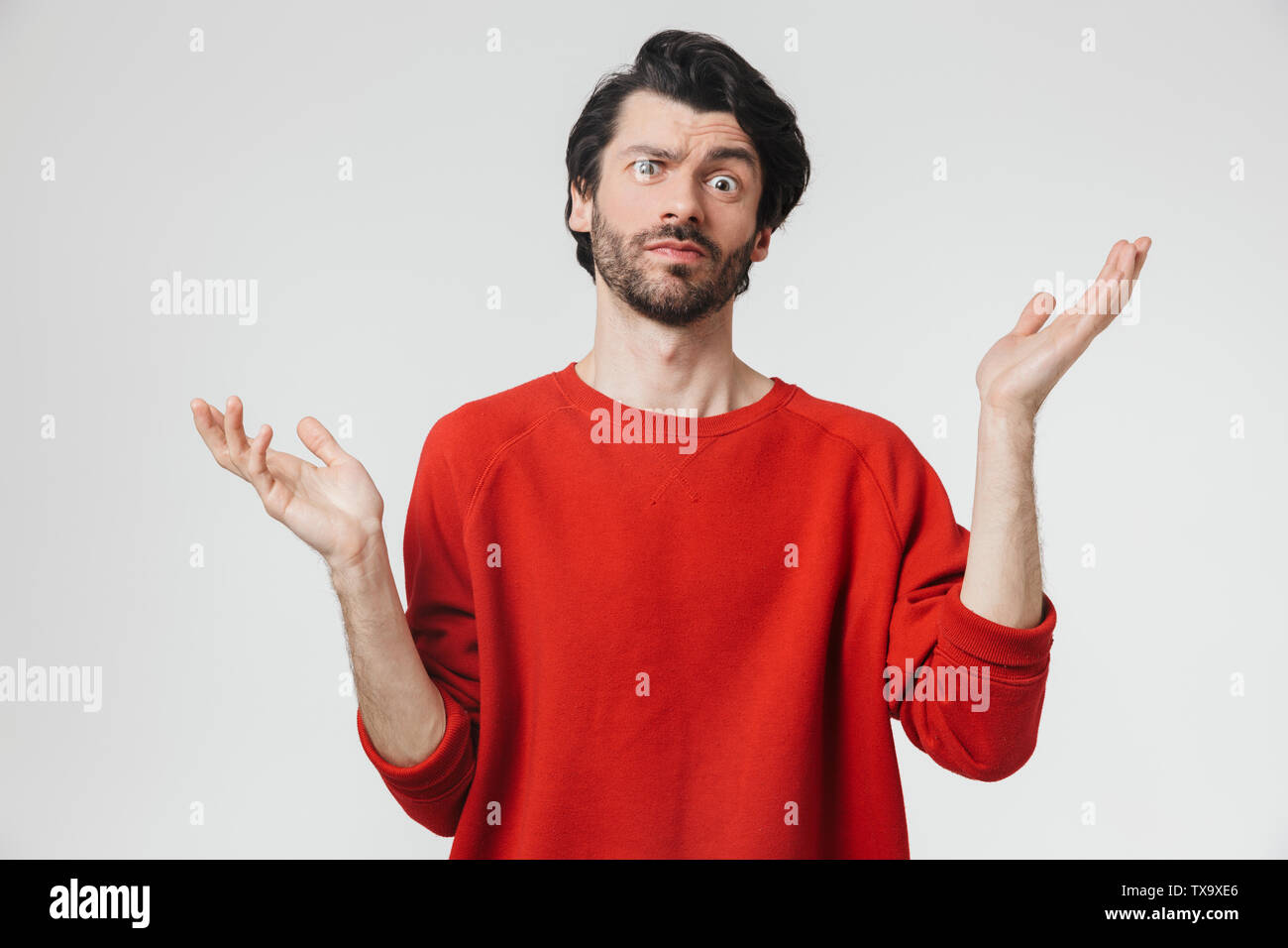 Image of a handsome confused young man isolated over white wall ...