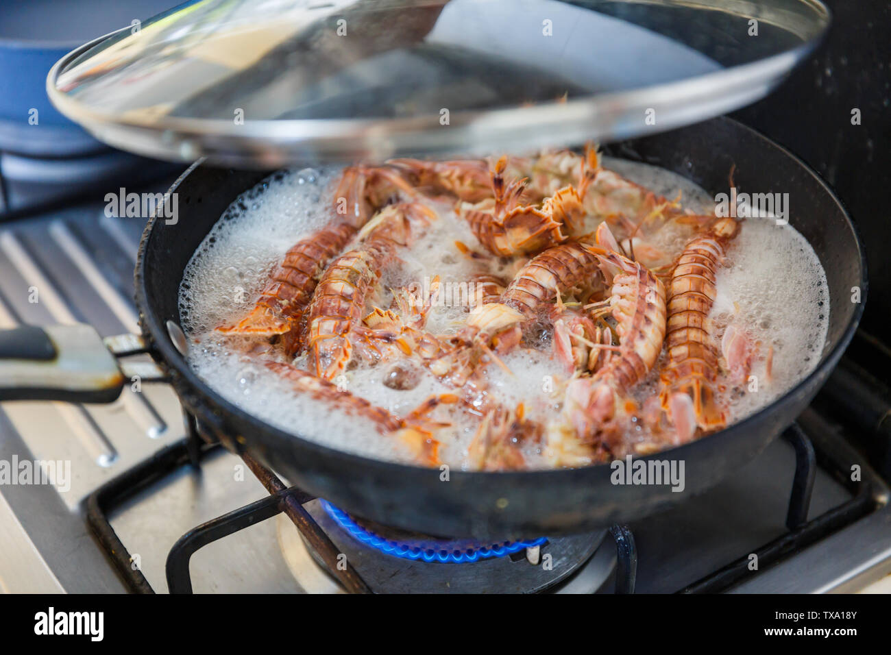 Cook Pippi shrimp in a large iron pan in the kitchen, the water boils ...