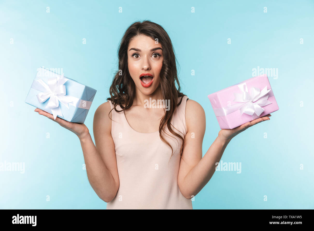 Portrait of an excited beautiful young brunette woman standing isolated ...