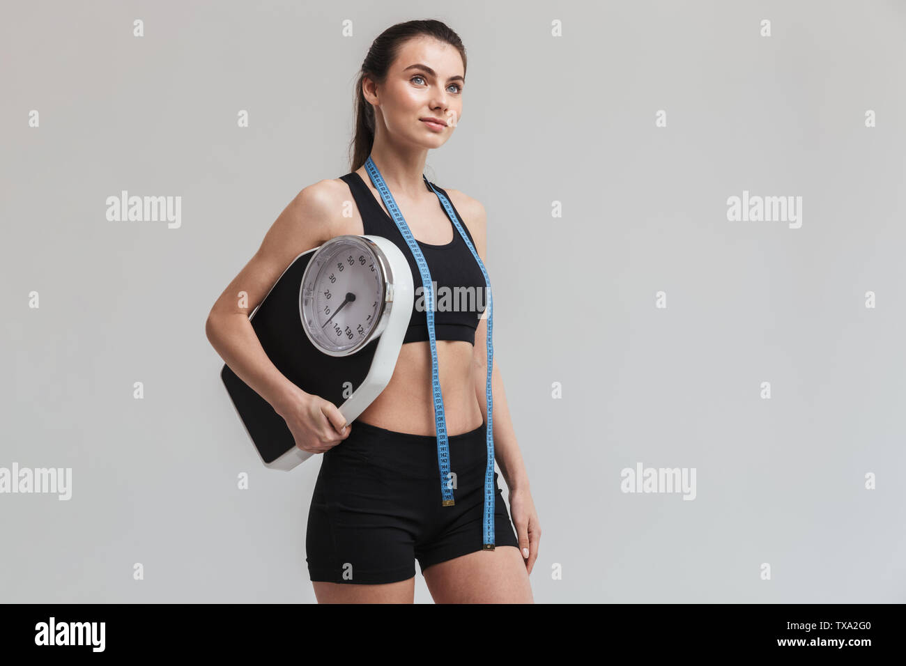 Image of a beautiful young sport fitness woman posing with scales ...