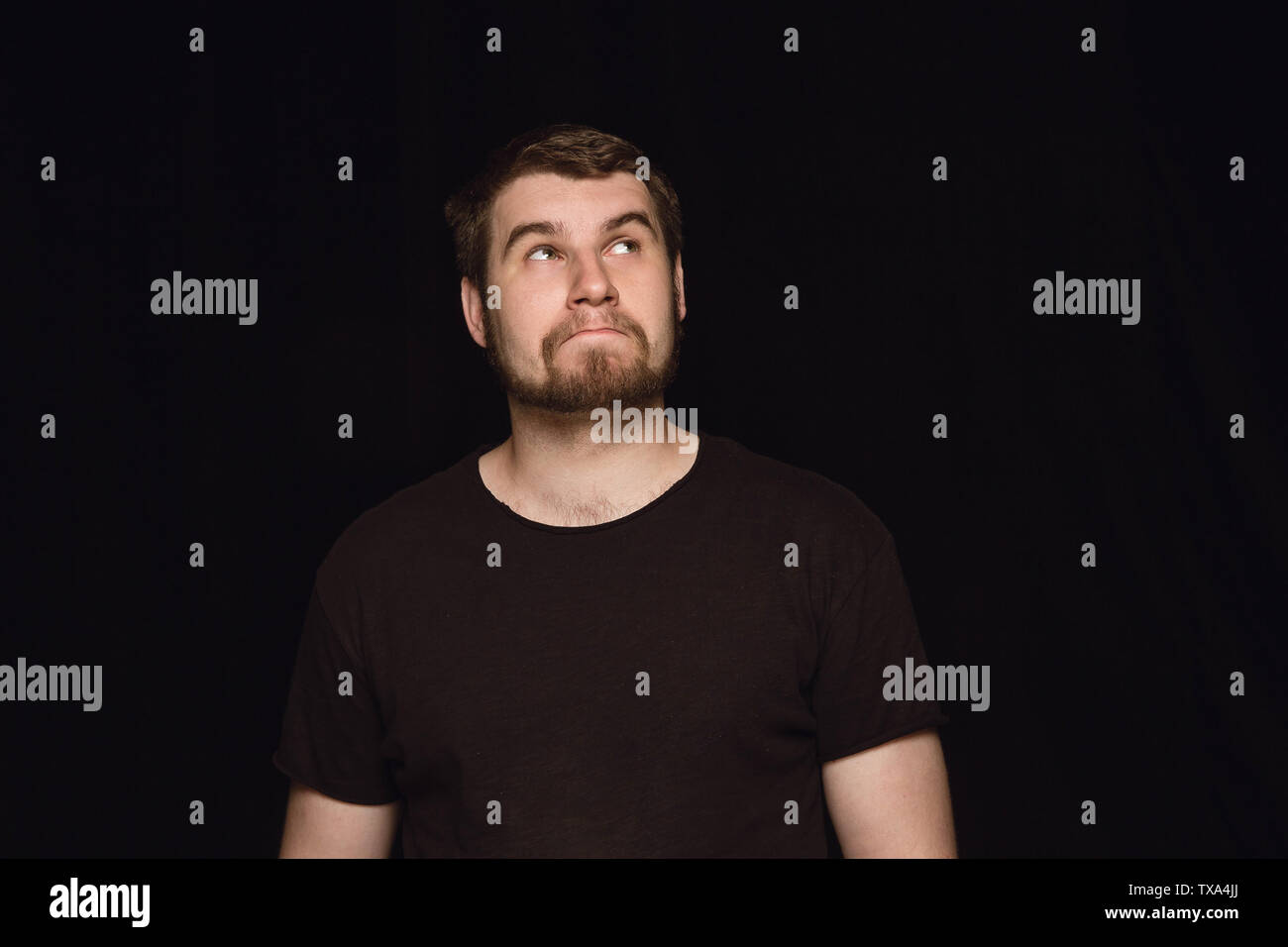Close up portrait of young man isolated on black studio background ...