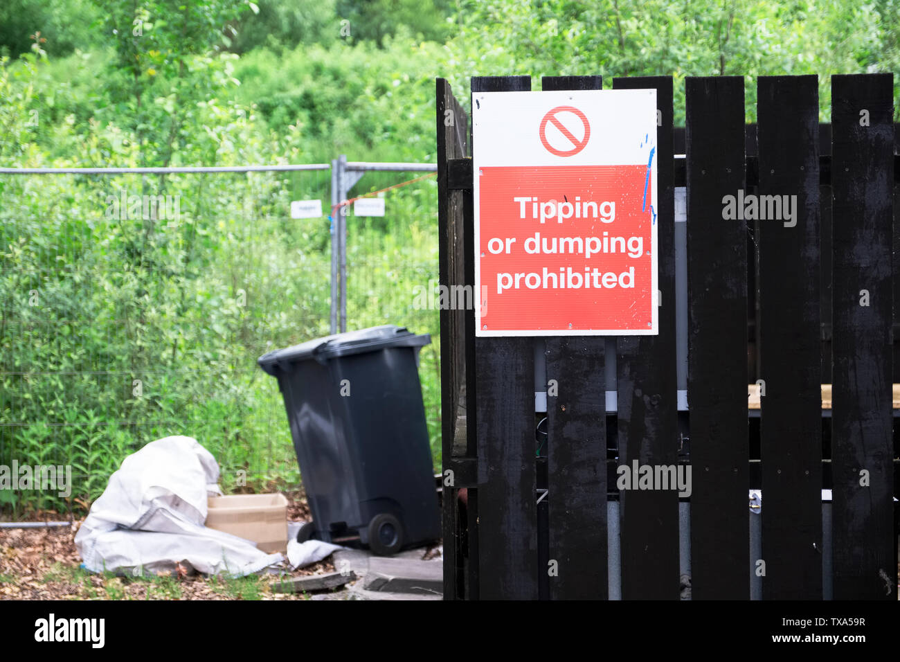 Flying tipping or dumping prohibited sign and bins Stock Photo - Alamy