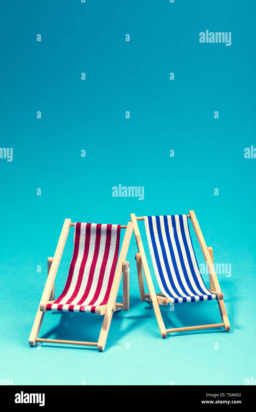 Two lounge chairs on blue background with copy space Stock Photo - Alamy